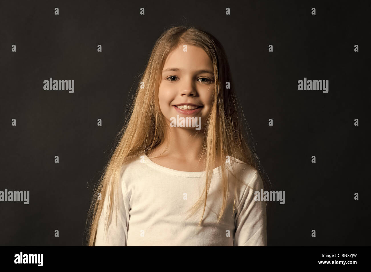 Kid model smiling with long healthy hair. Girl with smile on cute face ...