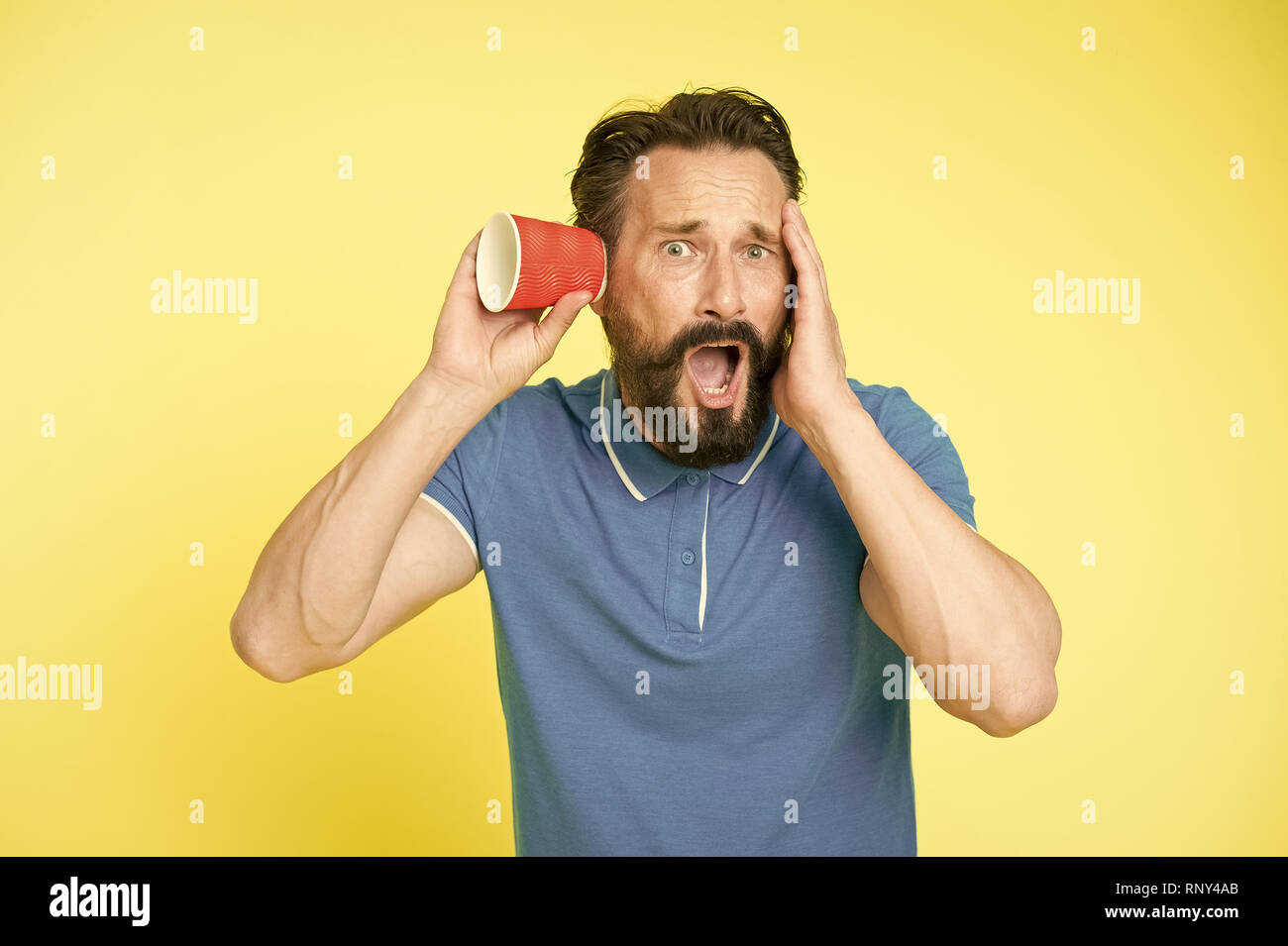 Shocking rumors. Man bearded mature guy eavesdrops with cup yellow ...