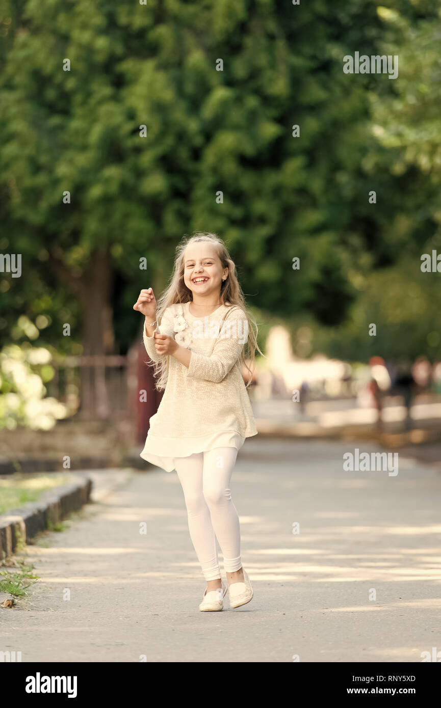 Child happy and cheerful enjoy walk in park. Childhood concept. Girl on ...