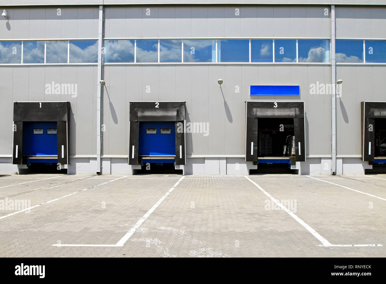 Three cargo door ramp at warehouse building Stock Photo - Alamy