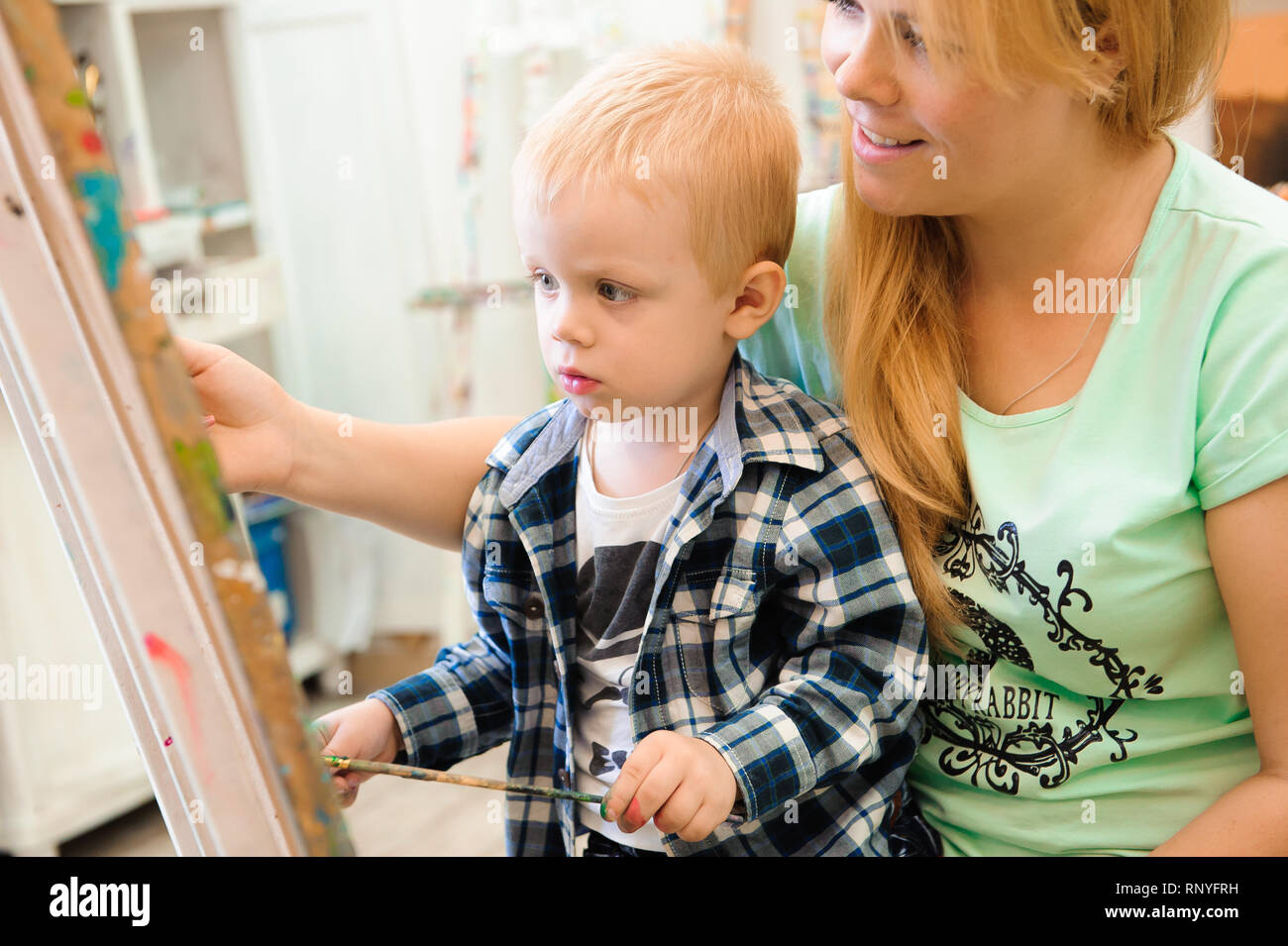 Mother and child draw a picture paints, art lesson Stock Photo - Alamy