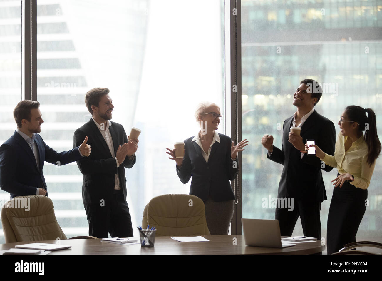 Happy executive team dancing to music having fun in office Stock Photo ...