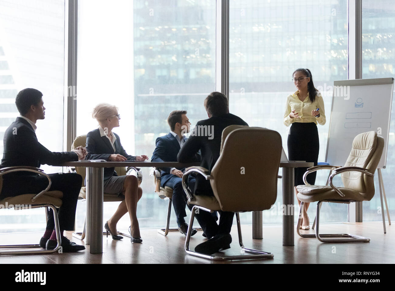 Asian coach giving business presentation at board multi-ethnic team ...