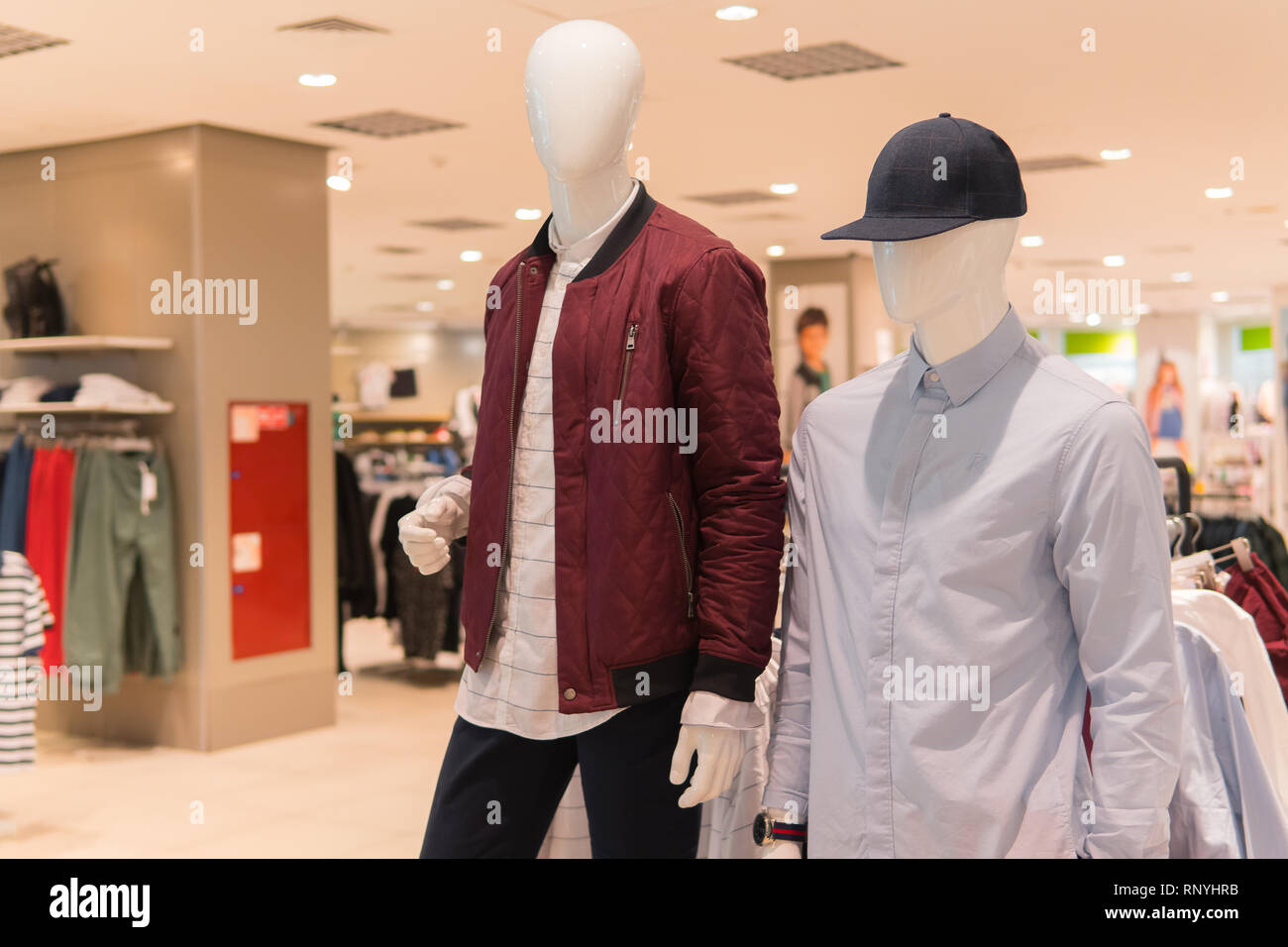 Male mannequins in red jacket, gray shirt and black baseball cap ...