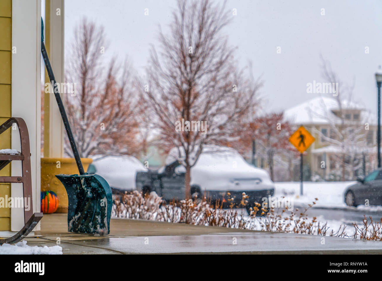 Snow shovel with snowy street in the background Stock Photo - Alamy