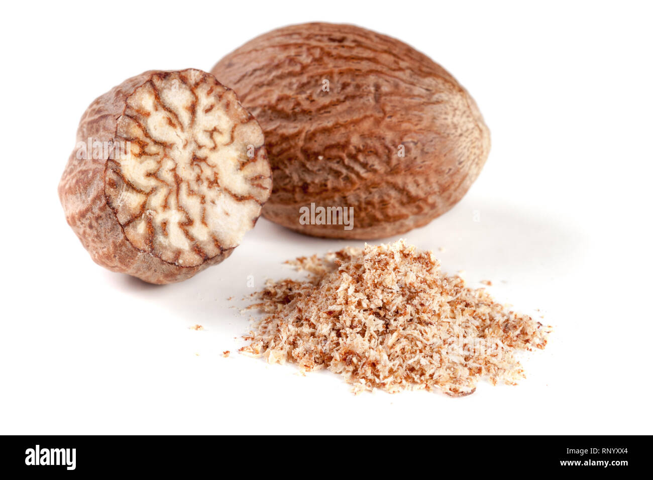 Two nutmeg and powder isolated on white background Stock Photo - Alamy