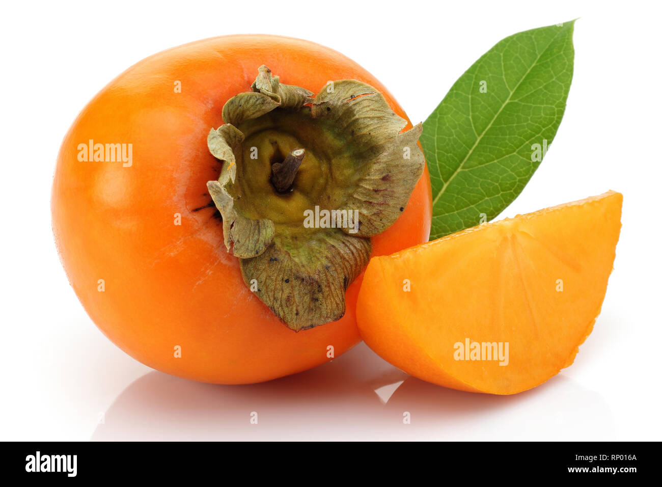 Slice and whole Persimmon with green leaf isolated on white background ...