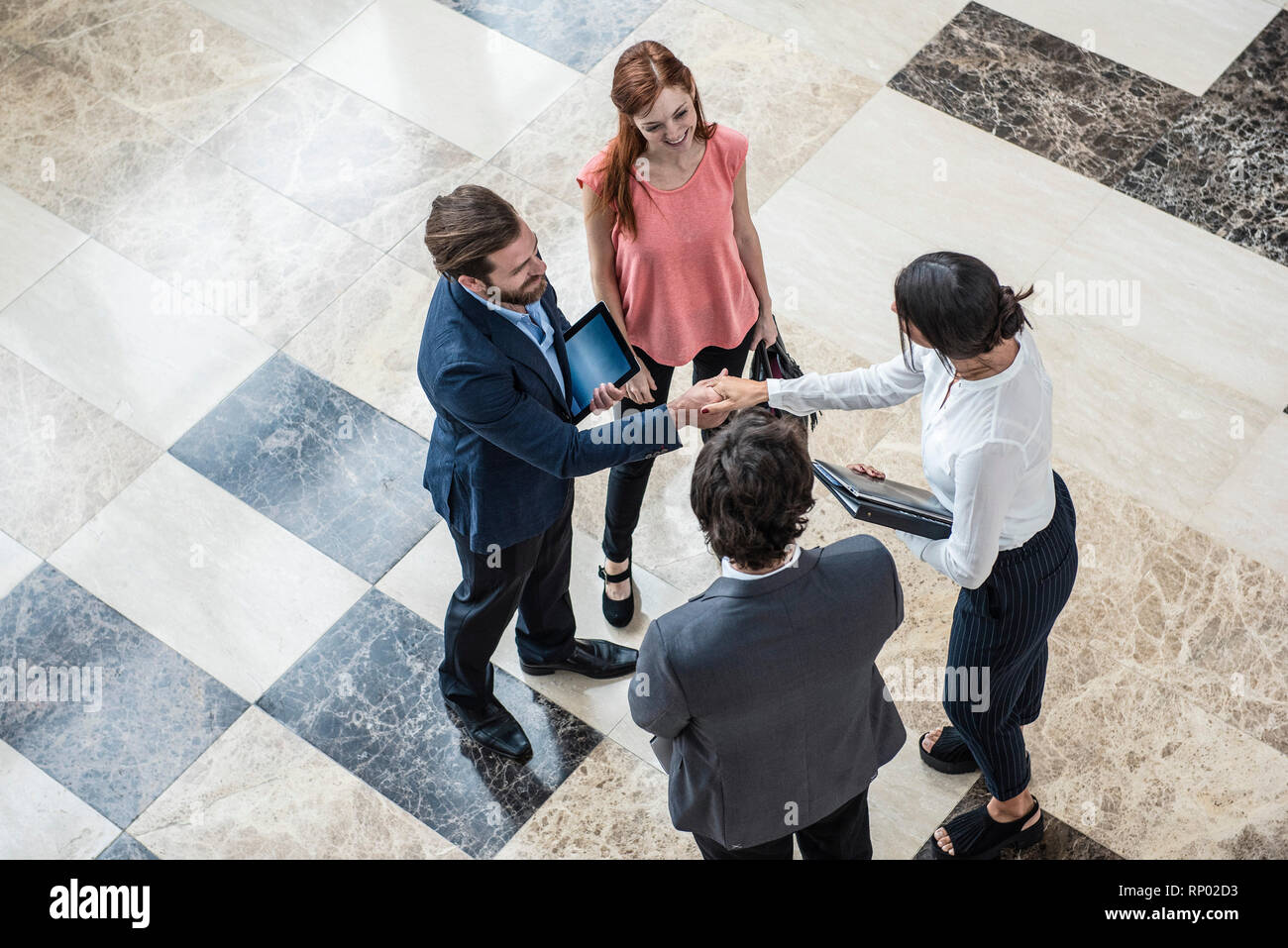 Business people greeting each other in hotel lobby Stock Photo - Alamy