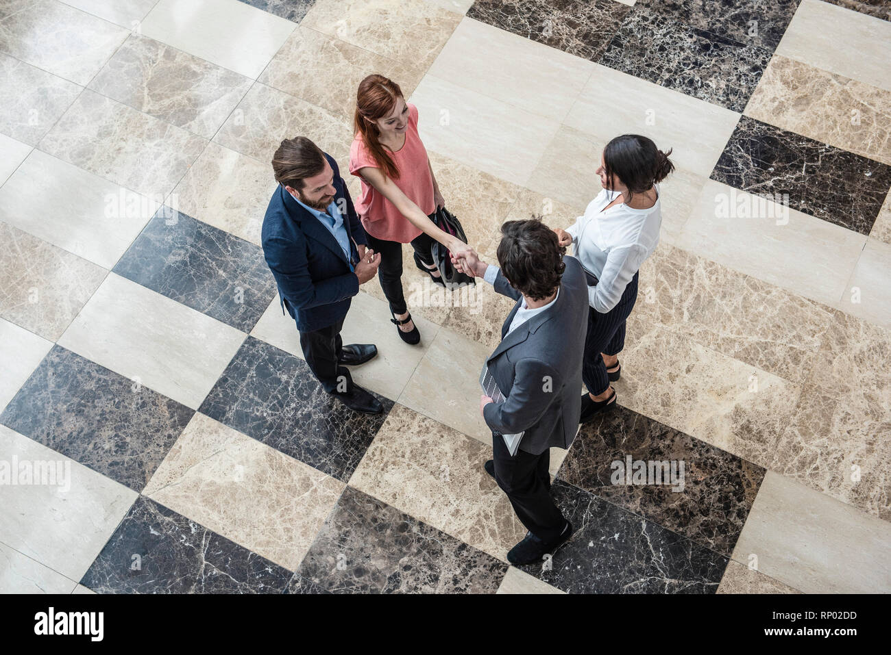 Business people greeting each other in hotel lobby Stock Photo - Alamy