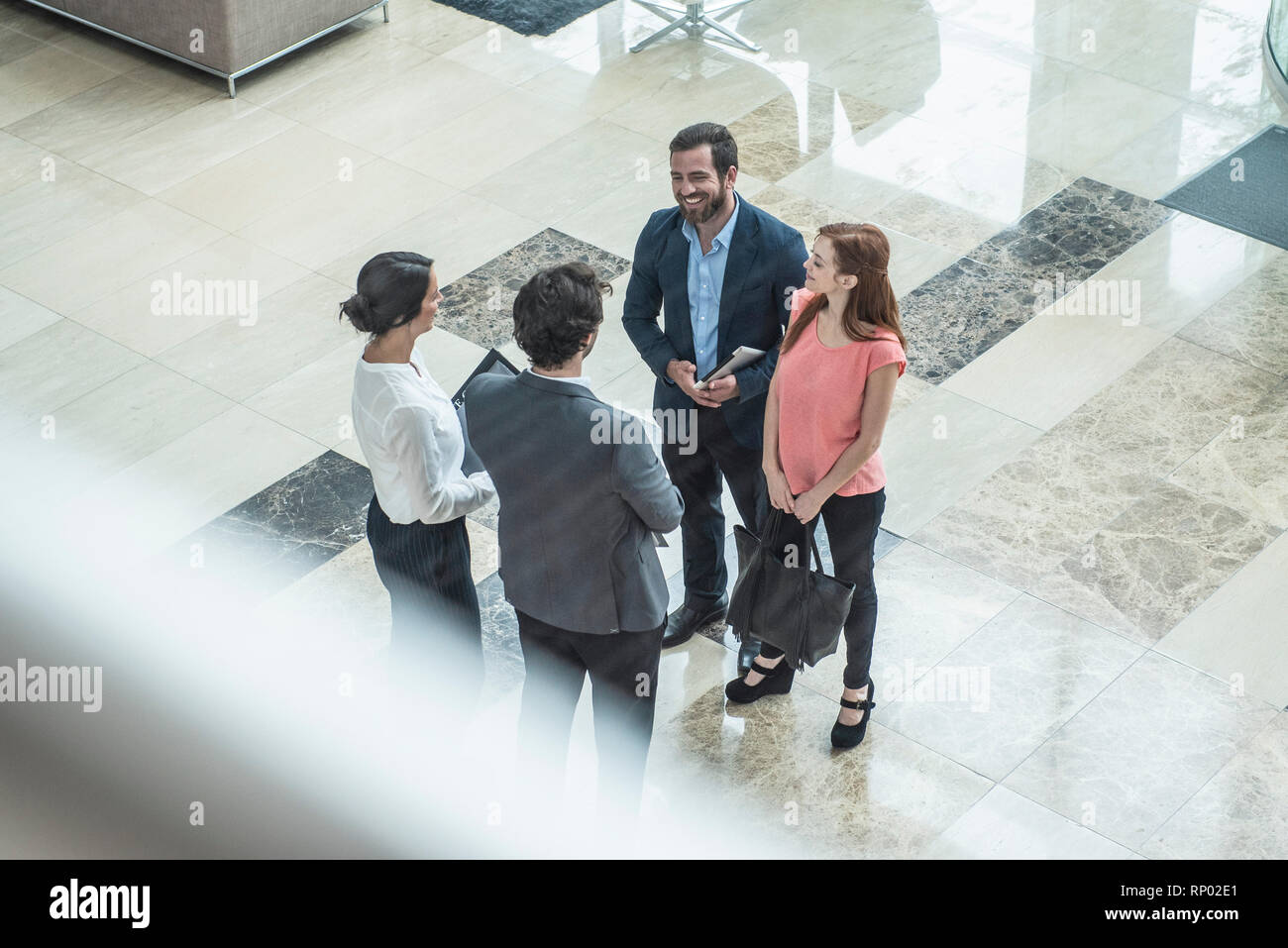 Business people talking with each other in hotel lobby Stock Photo - Alamy