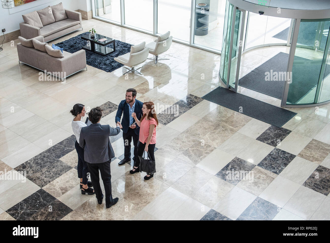 Business people greeting each other in hotel lobby Stock Photo - Alamy