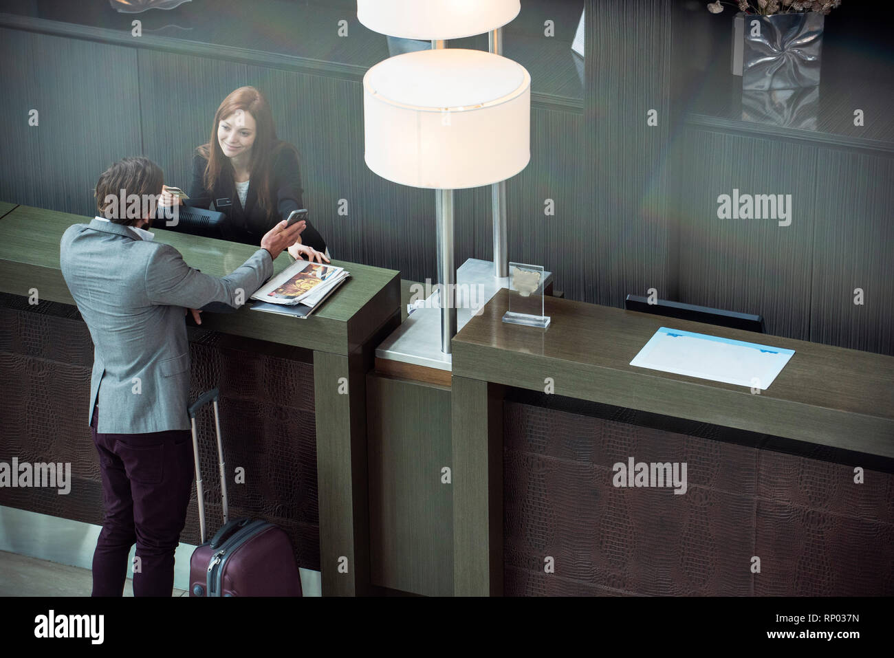 Hotel receptionist holding smartphone hi-res stock photography and ...