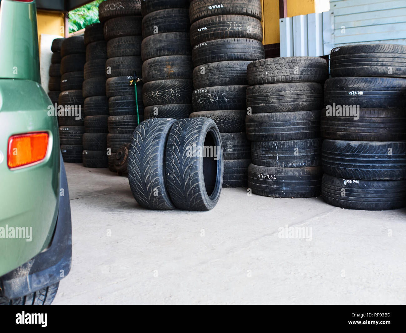Used car tires stacked in piles at junkyard. Old wheels recycling and ...