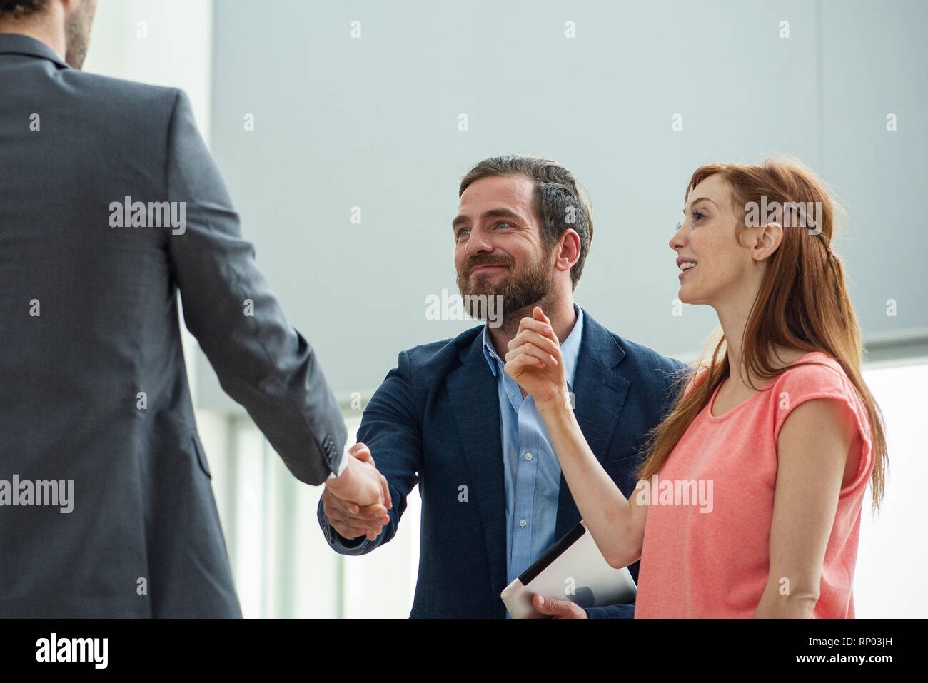 Business people greeting each other in hotel lobby Stock Photo - Alamy