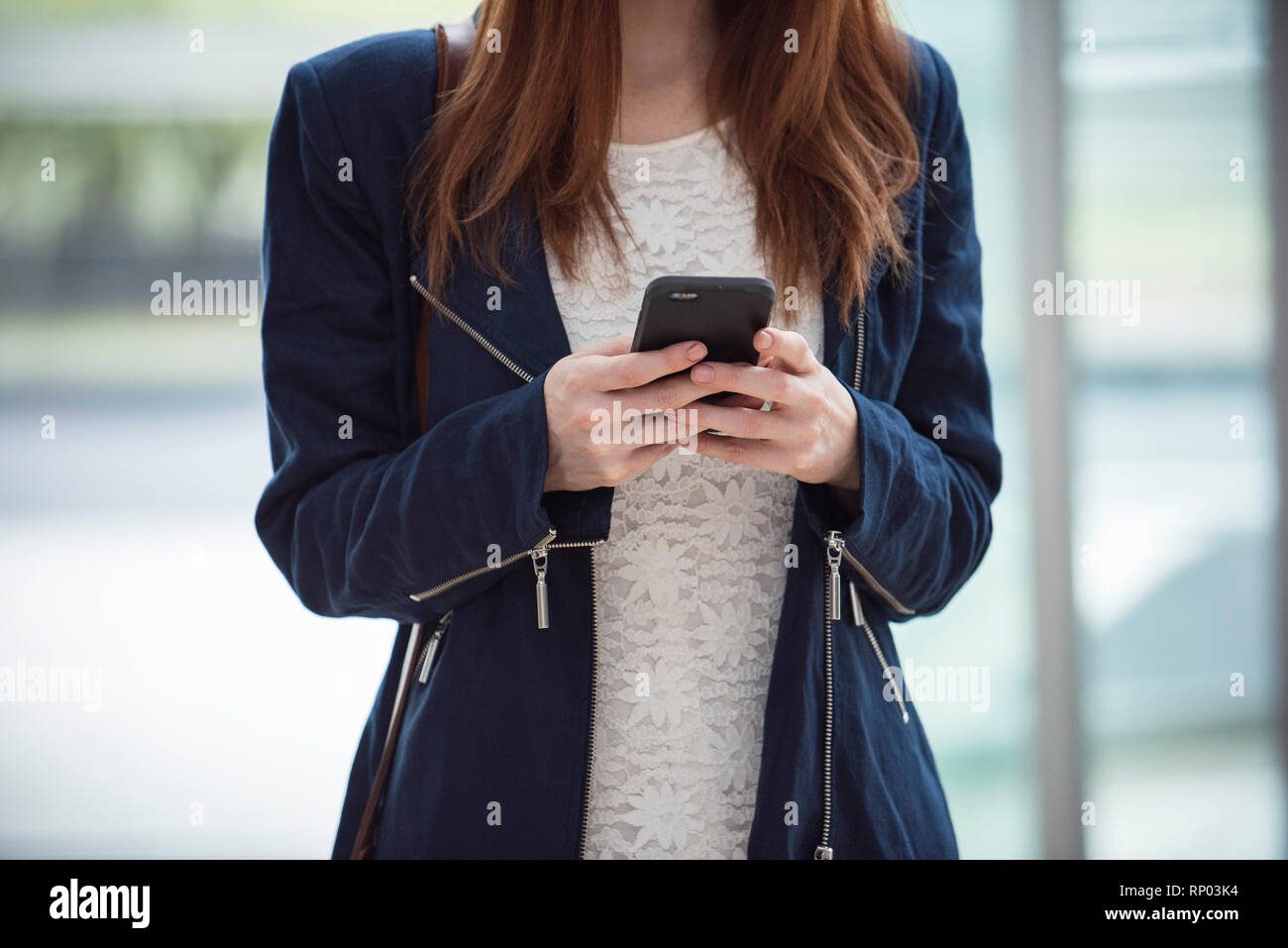 Woman using smart phone in hotel lobby Stock Photo - Alamy