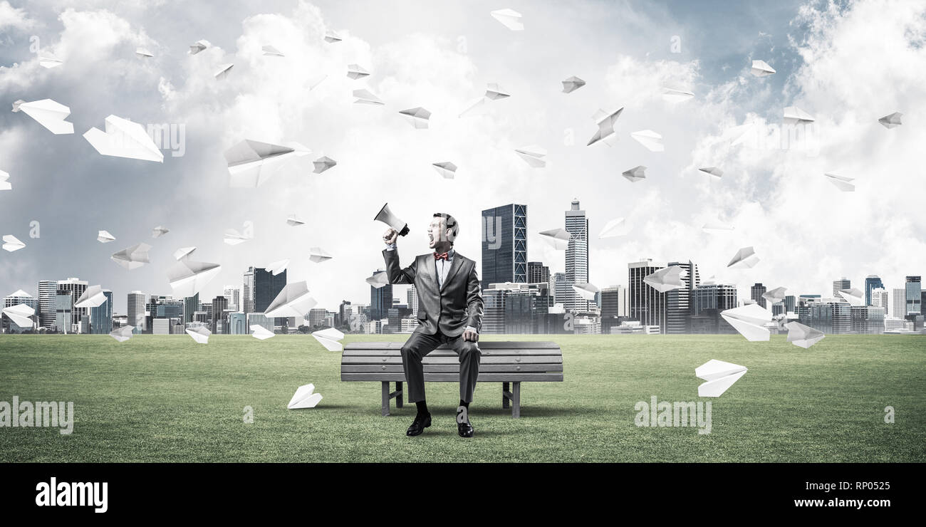 Businessman in summer park announcing something in loudspeaker and ...
