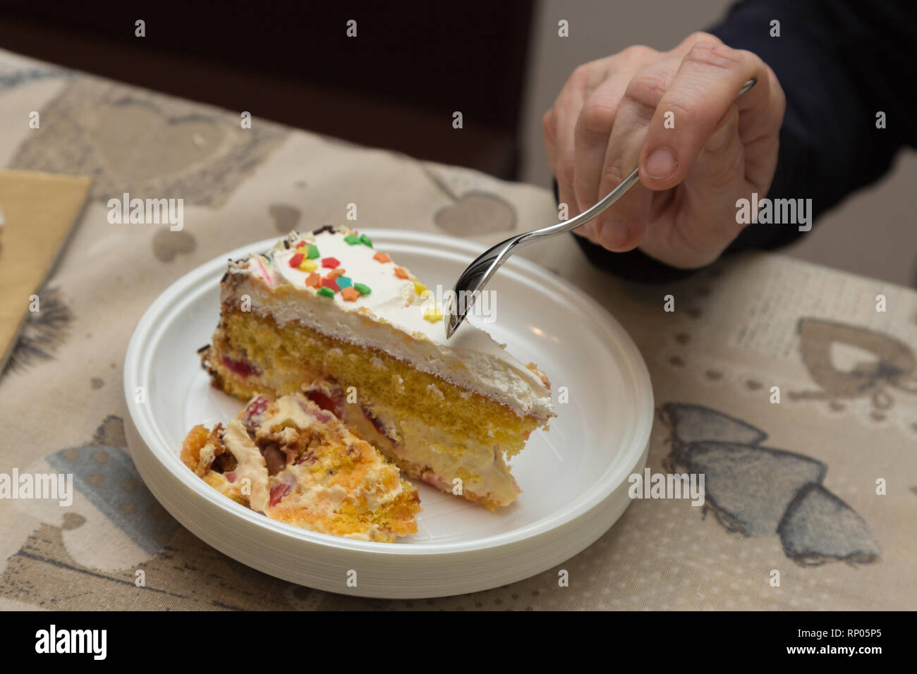 Eating with a Spoon a Slice of Birthday Cake with Cream in a Plastic ...