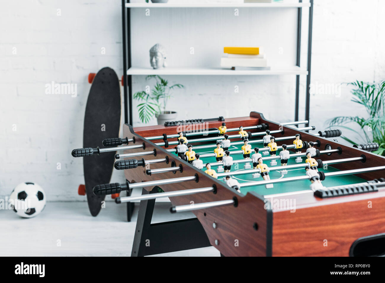 football table with shelving rack, longboard and soccer ball on ...