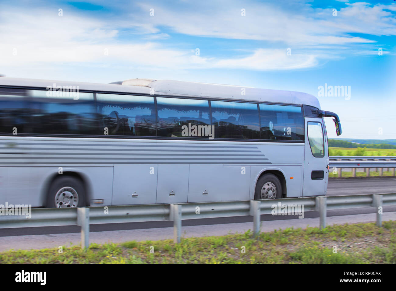 Tourist bus moves along the country highway Stock Photo - Alamy