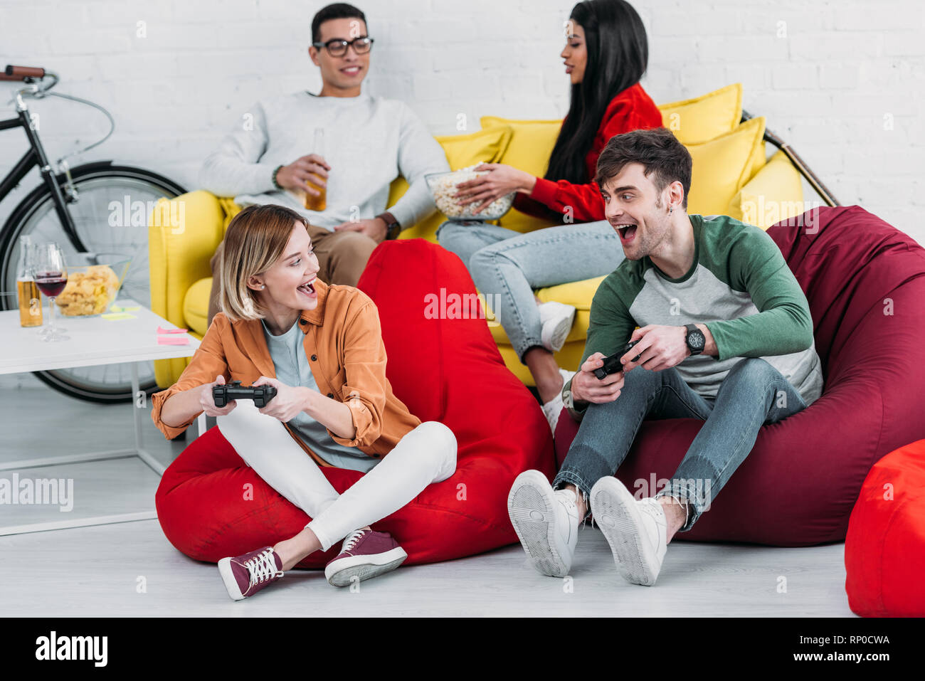 happy multicultural friends playing video game and enjoying drinks and ...