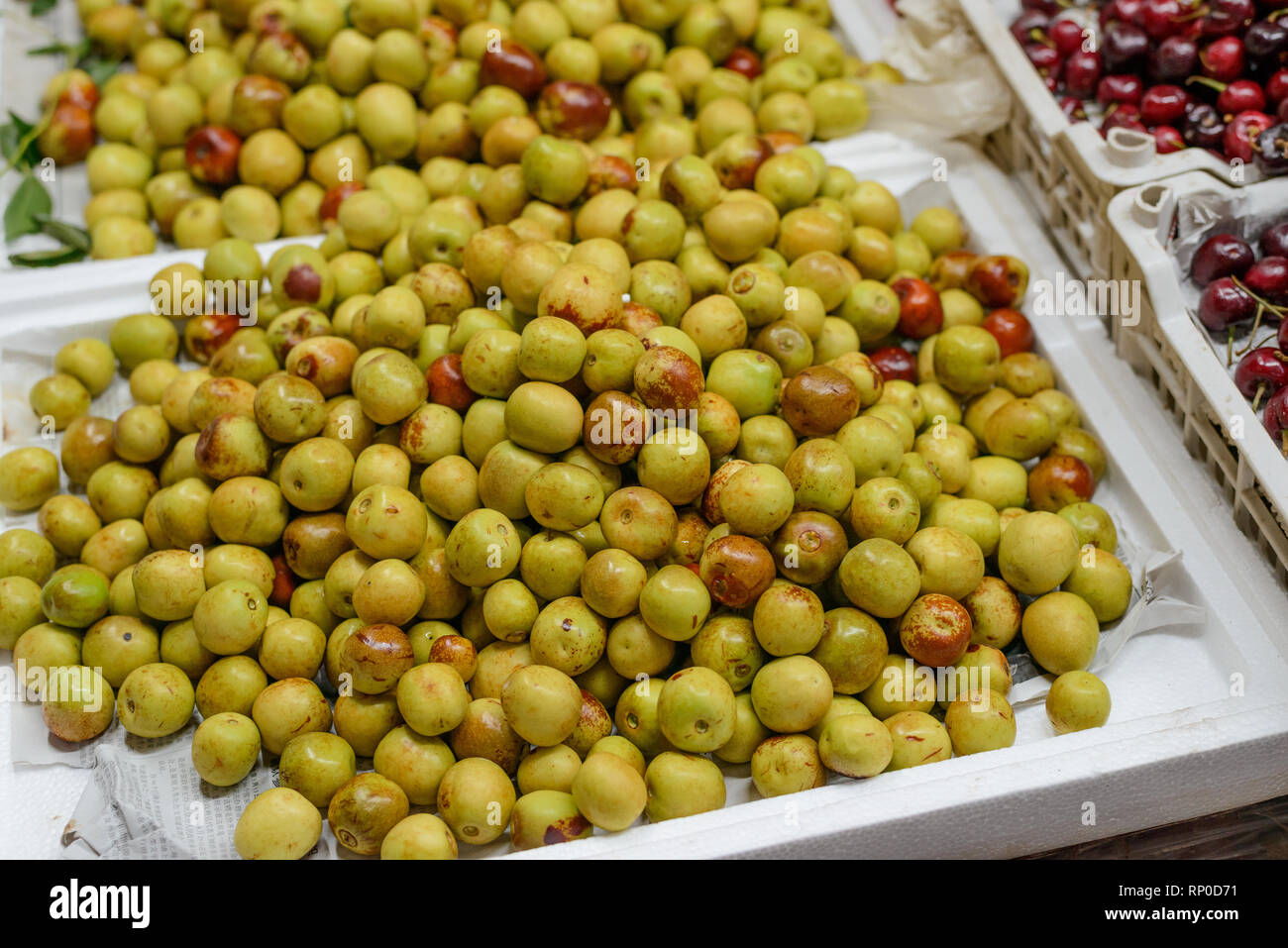 Green sour plums and cherries Stock Photo - Alamy
