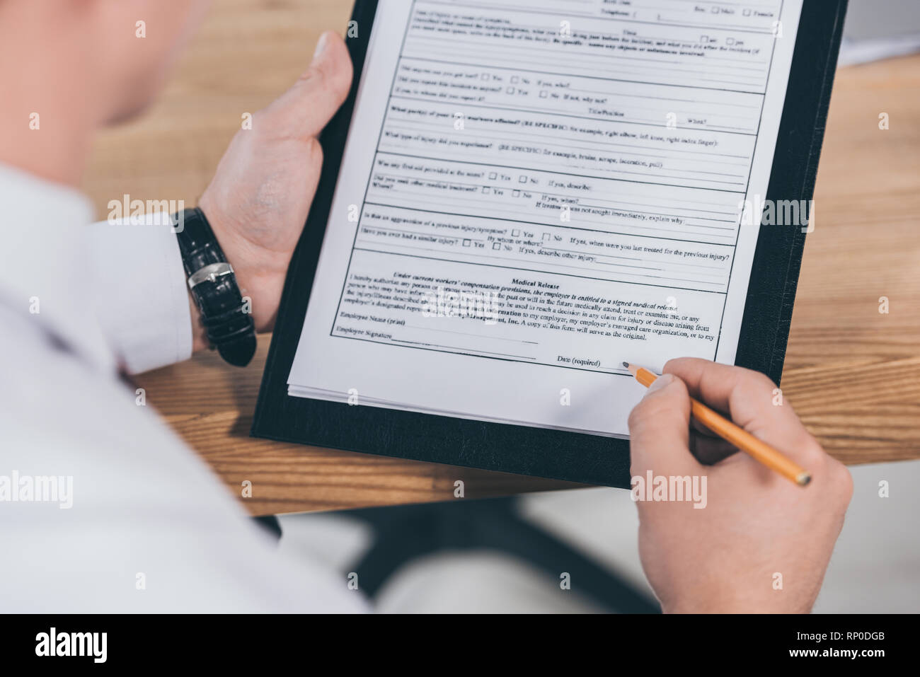 cropped view of businessman putting signature on compensation claim ...