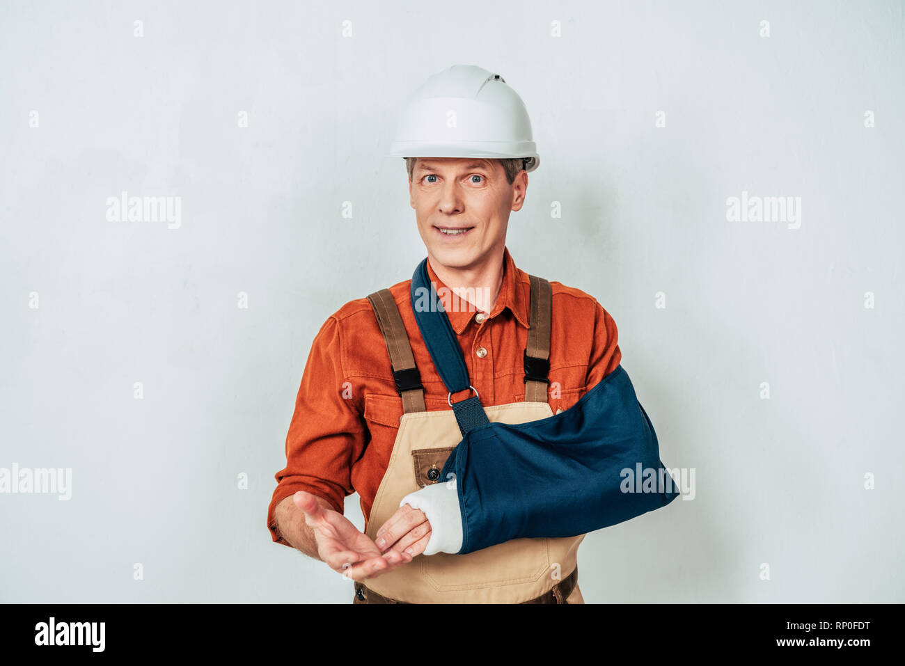 repairman with arm bandage standing on white background Stock Photo - Alamy