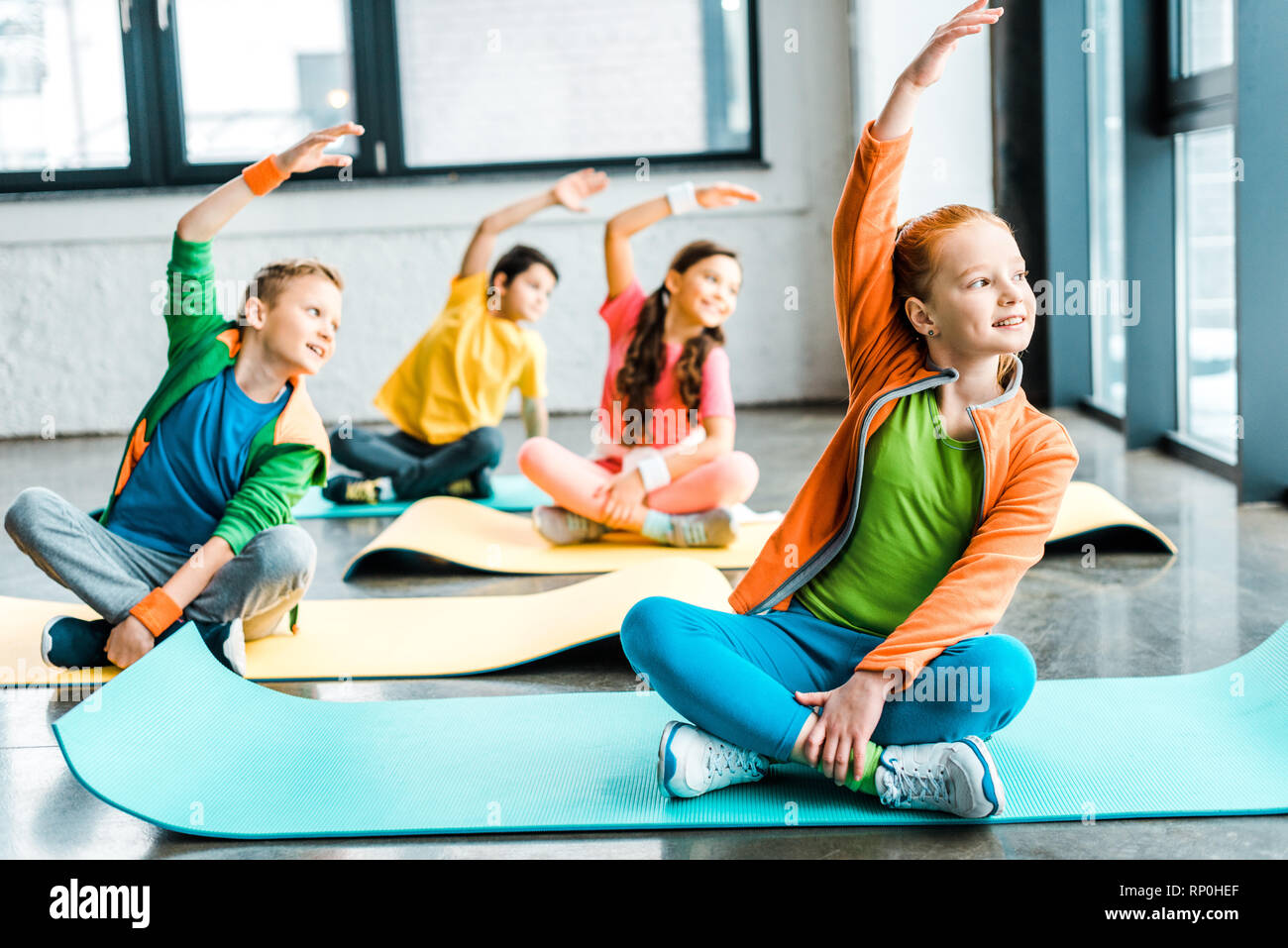 Happy kids stretching on fitness mats with smile Stock Photo - Alamy