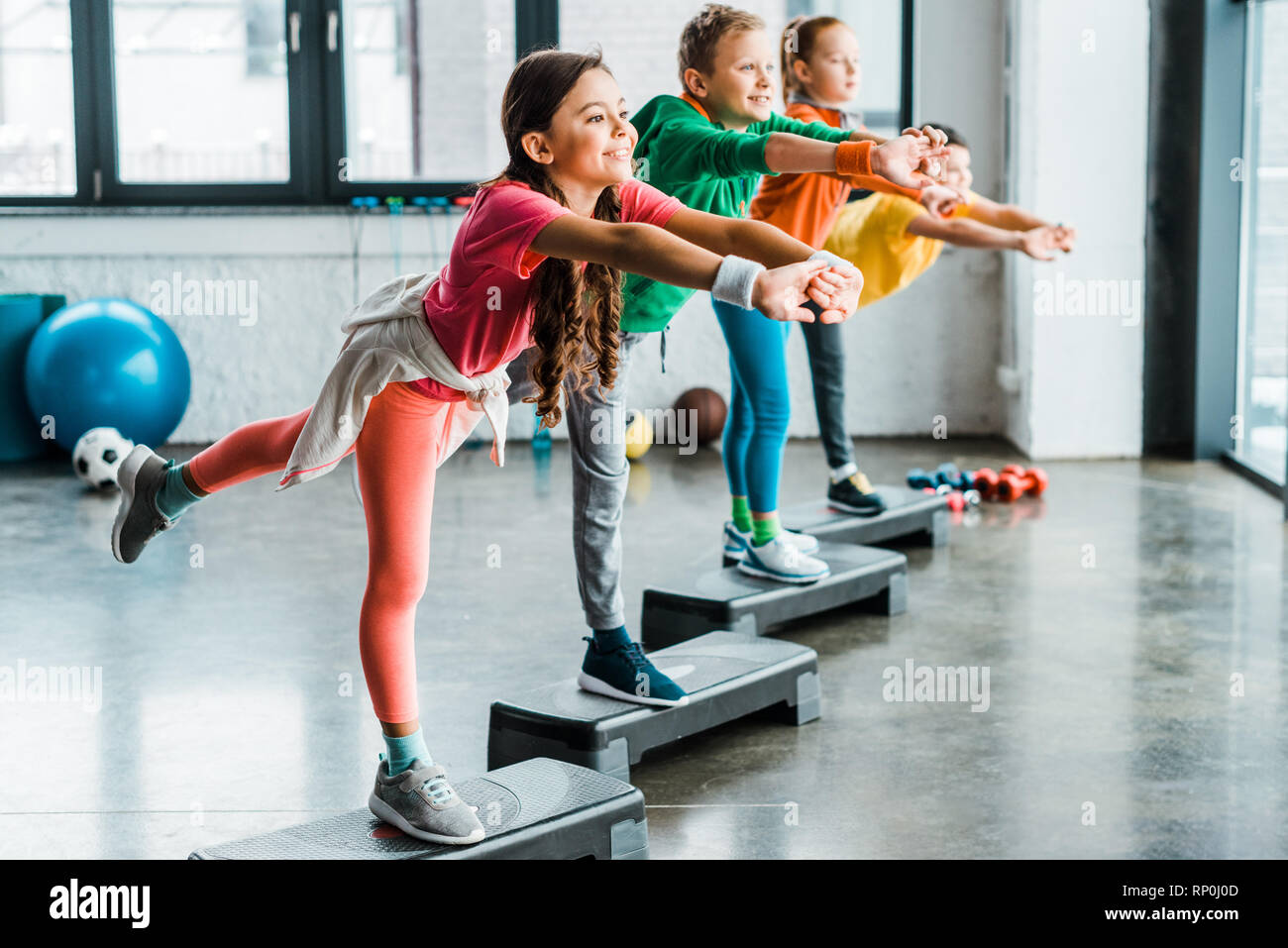 Cheerful kids doing exercises with step platforms Stock Photo - Alamy
