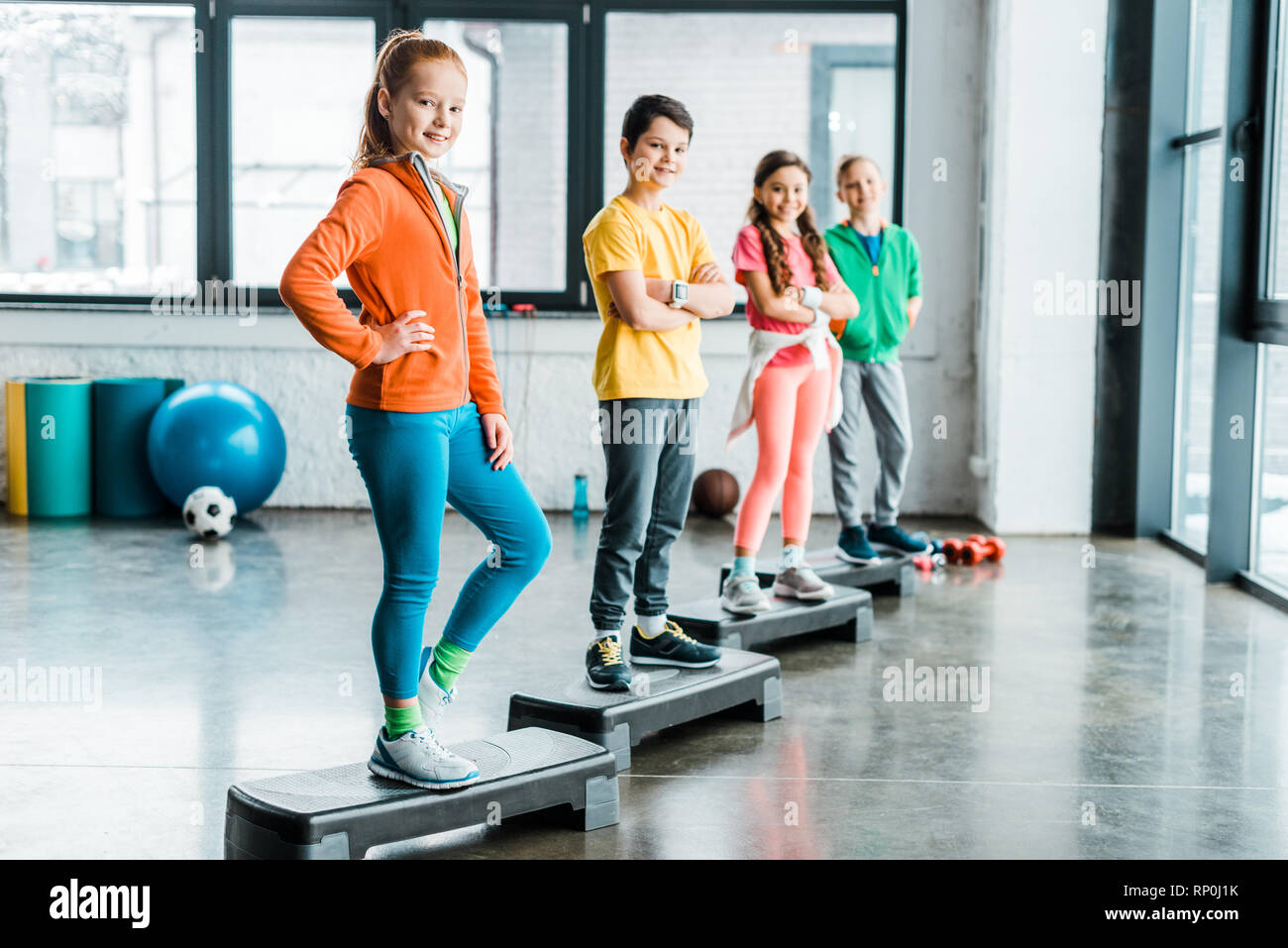 Adorable kids standing on step platforms in gym Stock Photo - Alamy