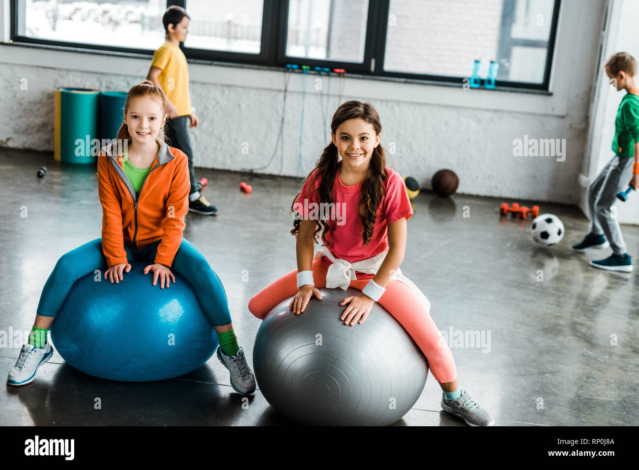 Kids posing with smile while sitting on fitness balls Stock Photo - Alamy