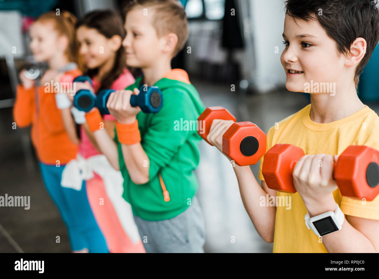 Cute children training with colorful dumbbells Stock Photo - Alamy