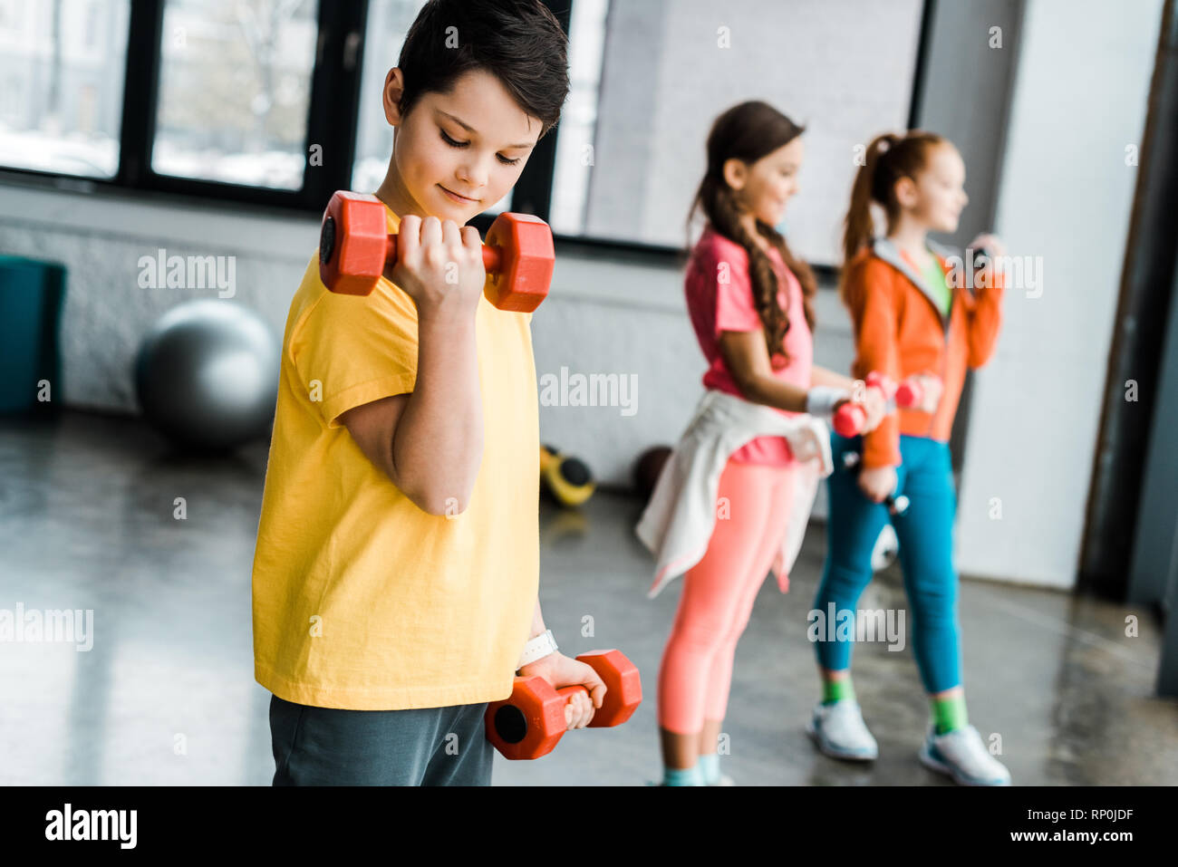 Preteen kids training with dumbbells in gym Stock Photo - Alamy