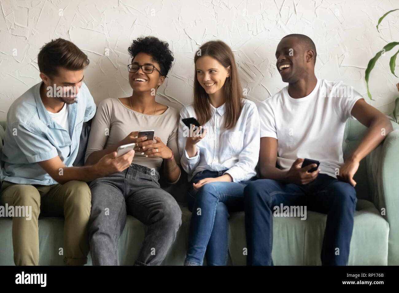 Friends laughing mobile device watching hi-res stock photography and ...