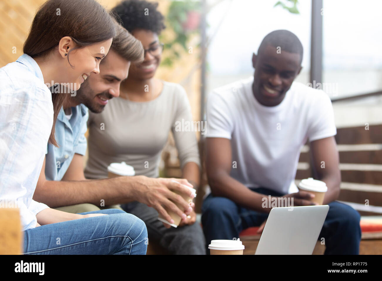 Friends sitting in cafe watching movie on computer Stock Photo - Alamy