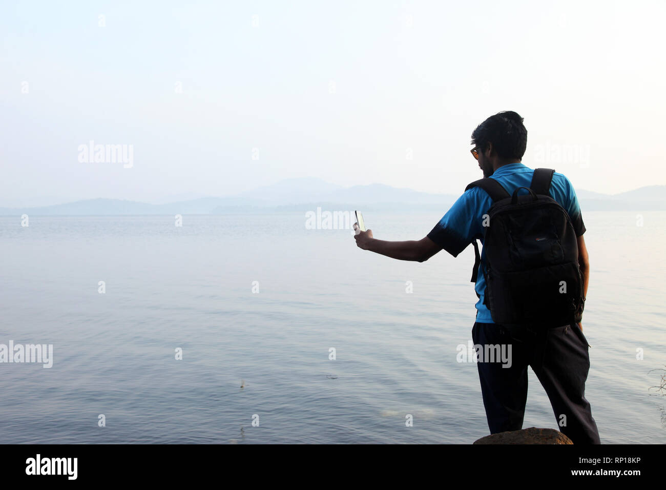 A young man on phone call near the pond in india Stock Photo - Alamy