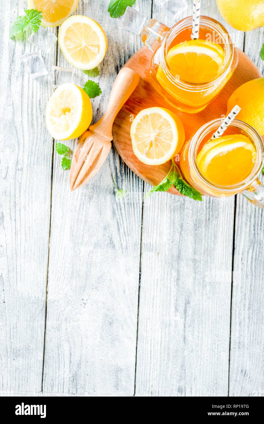 Iced summer drink, tea with lemon slices and mint, rustic wooden ...