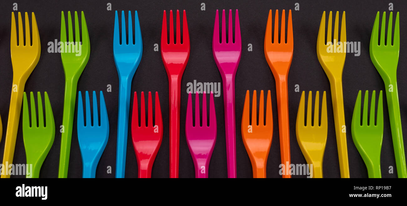 Many color plastic forks on a bright background Stock Photo - Alamy