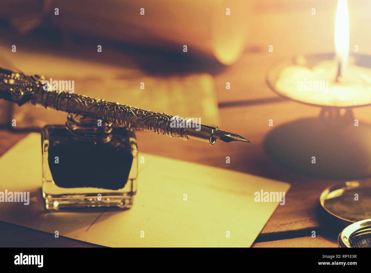 old quill pen and inkwell on brown wooden table with candle Stock Photo ...