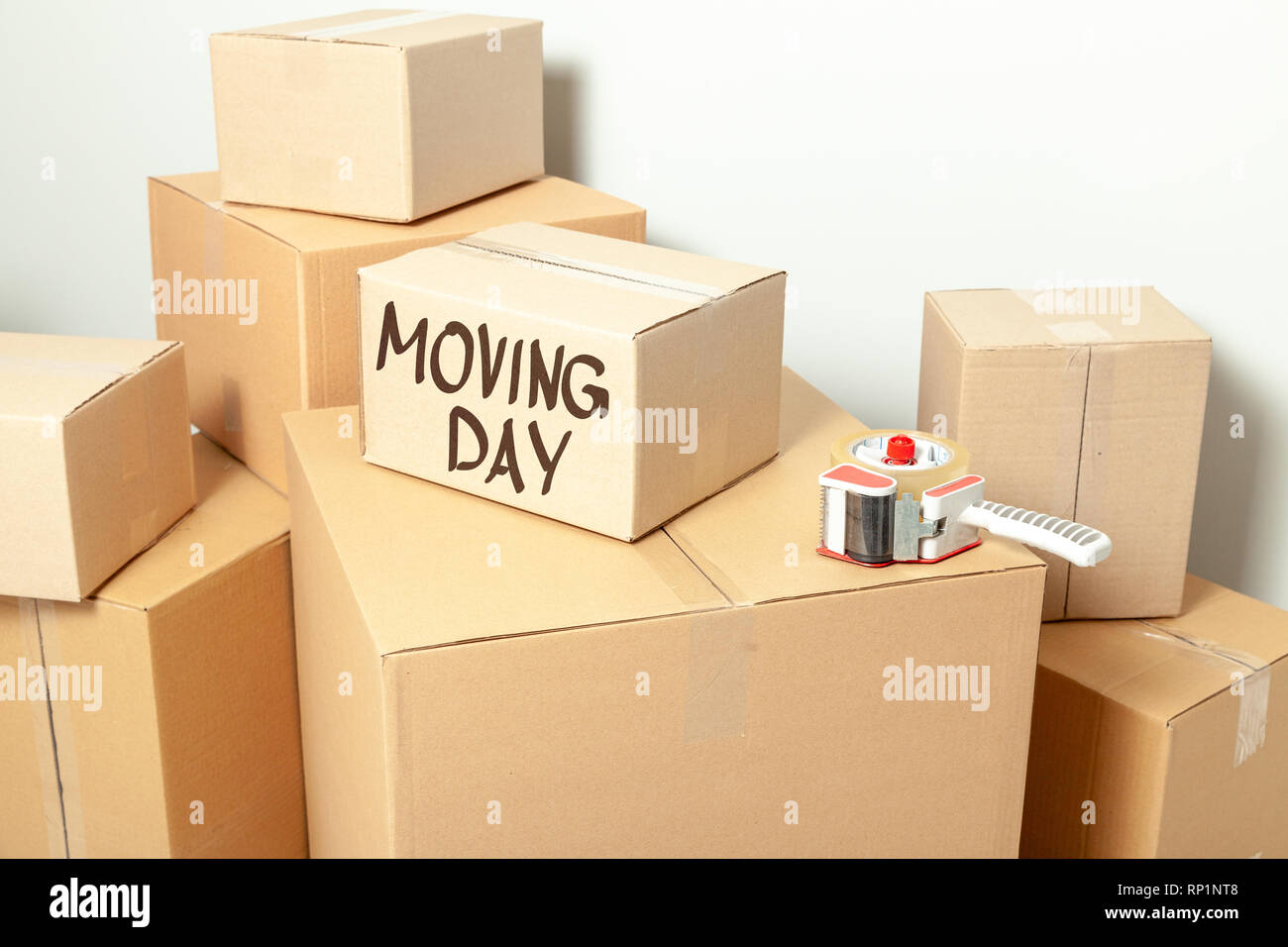 Day moving. Cardboard boxes on gray wall background Stock Photo - Alamy