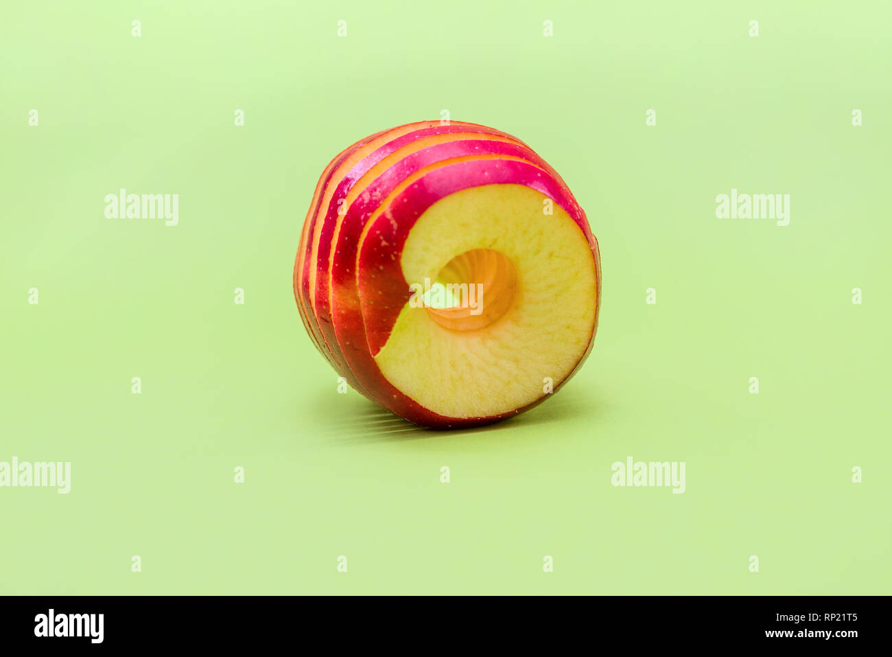 fresh ripe red apple sliced in circles. green background Stock Photo ...