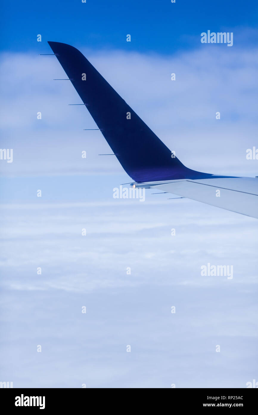 Tail of an airplane on a flight in the blue sky background. Copy space ...