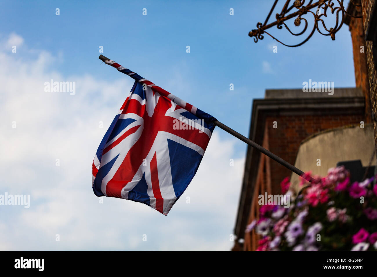 Great Britain flag on the house with flowers. State flaf with blue sky ...