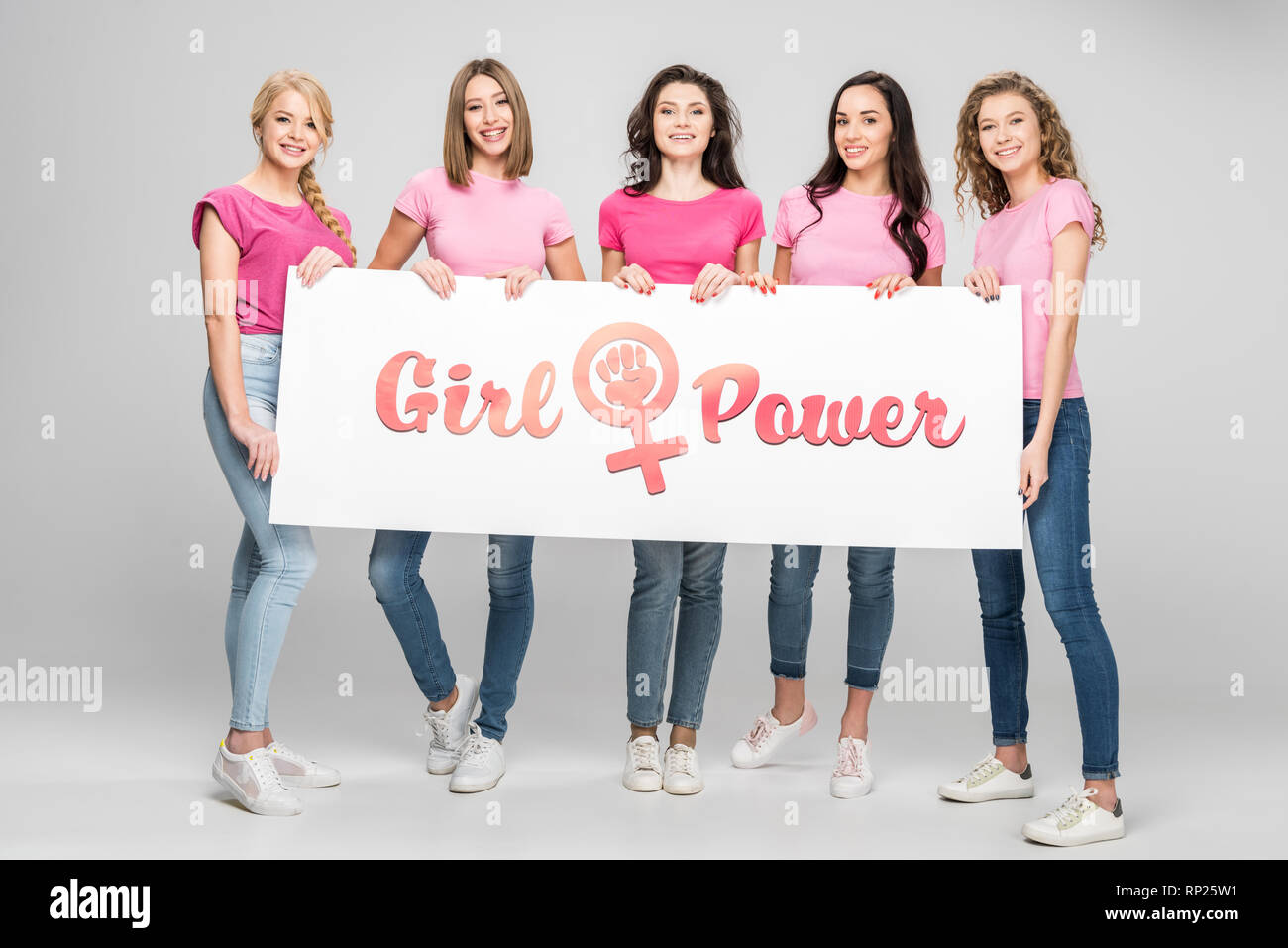beautiful young women holding large sign with girl power lettering on ...