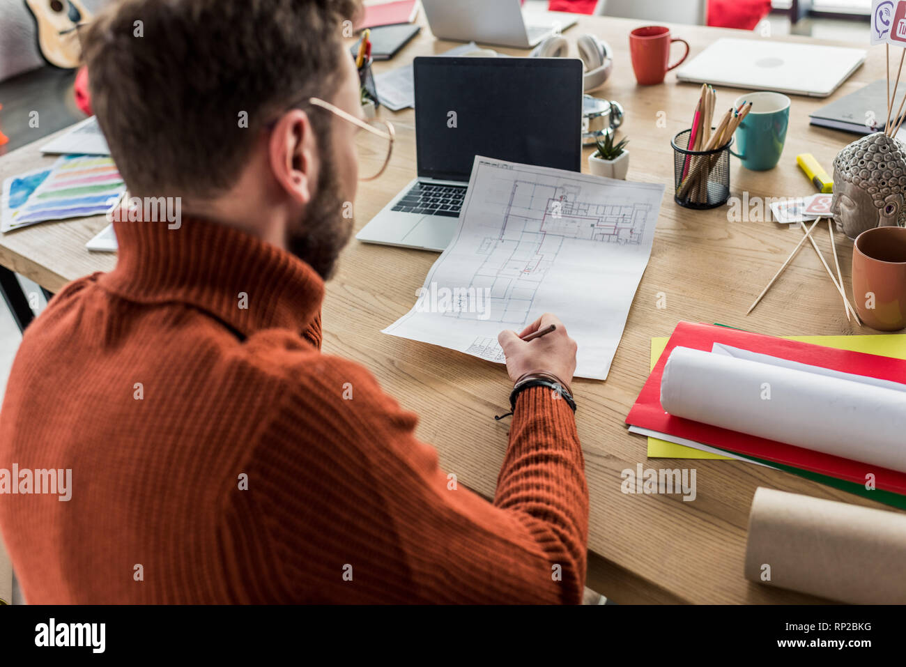 back view of male architect sitting at computer desk and working on ...