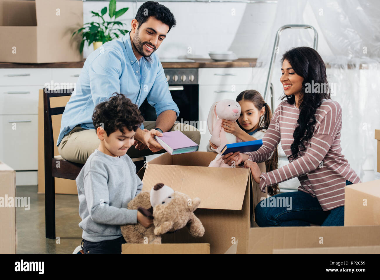 happy latin family unpacking boxes in new home Stock Photo - Alamy