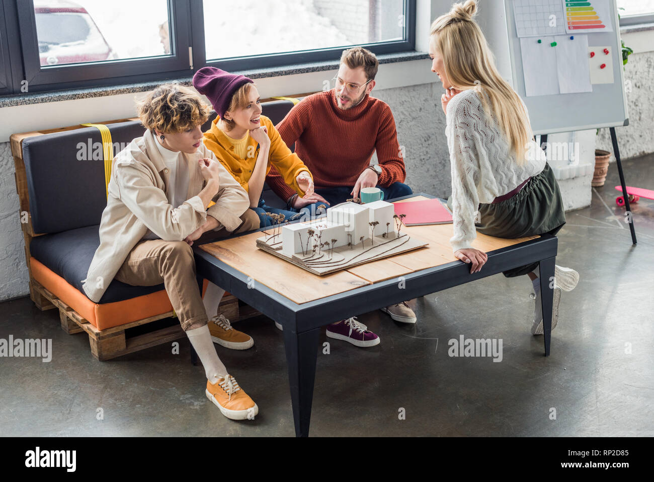 group of female and male architects sitting at table and working on ...