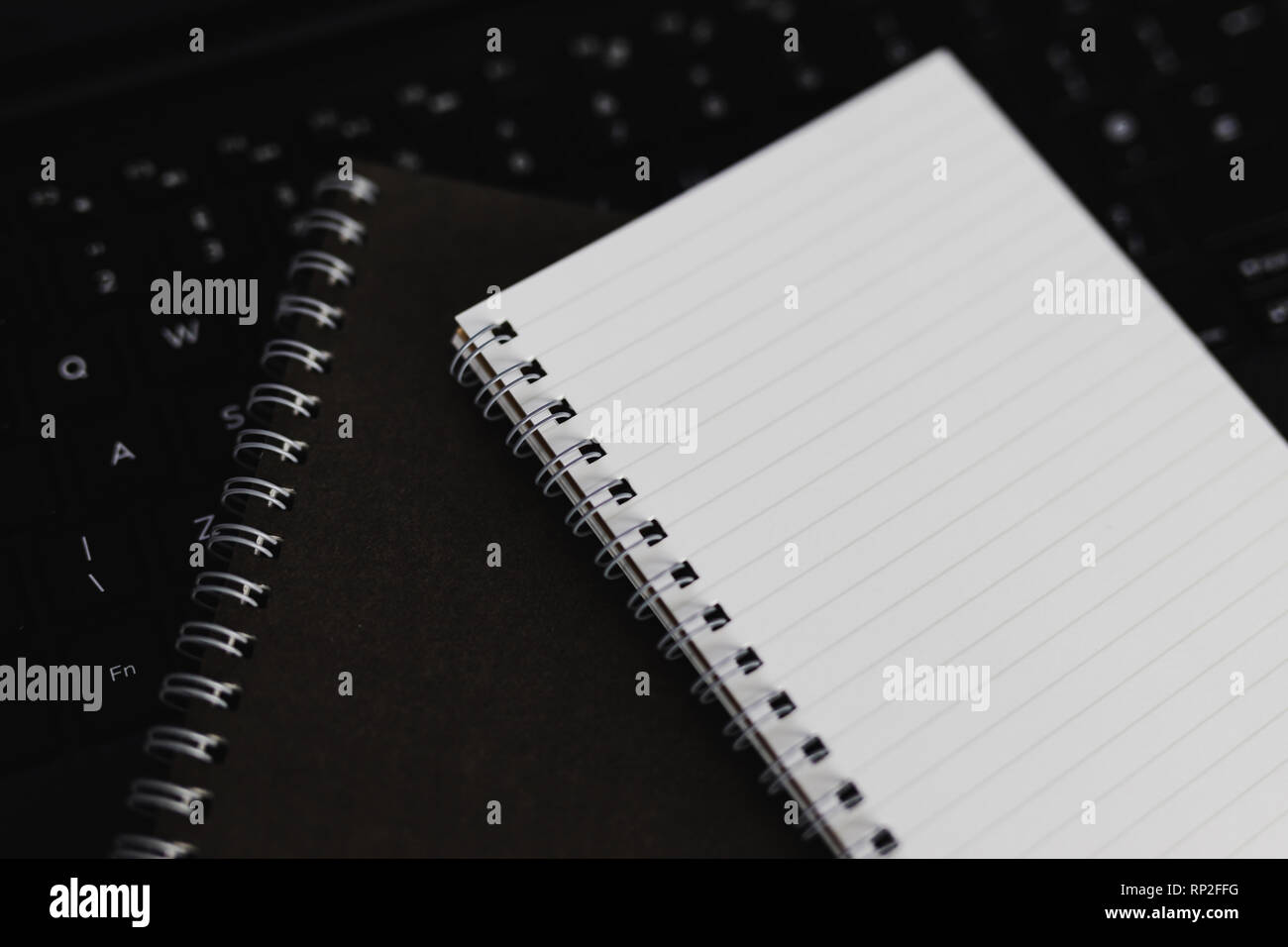 2 paper notepads on top of laptop keyboard, concept of technology vs ...