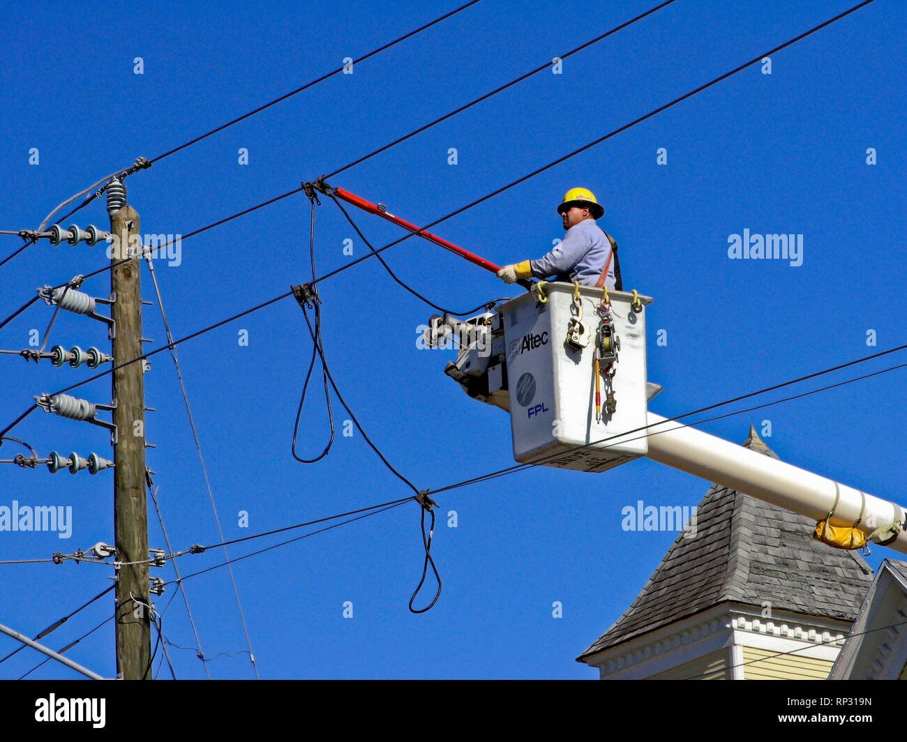 lineman installing jumper cable; bucket truck; electric wires; job ...