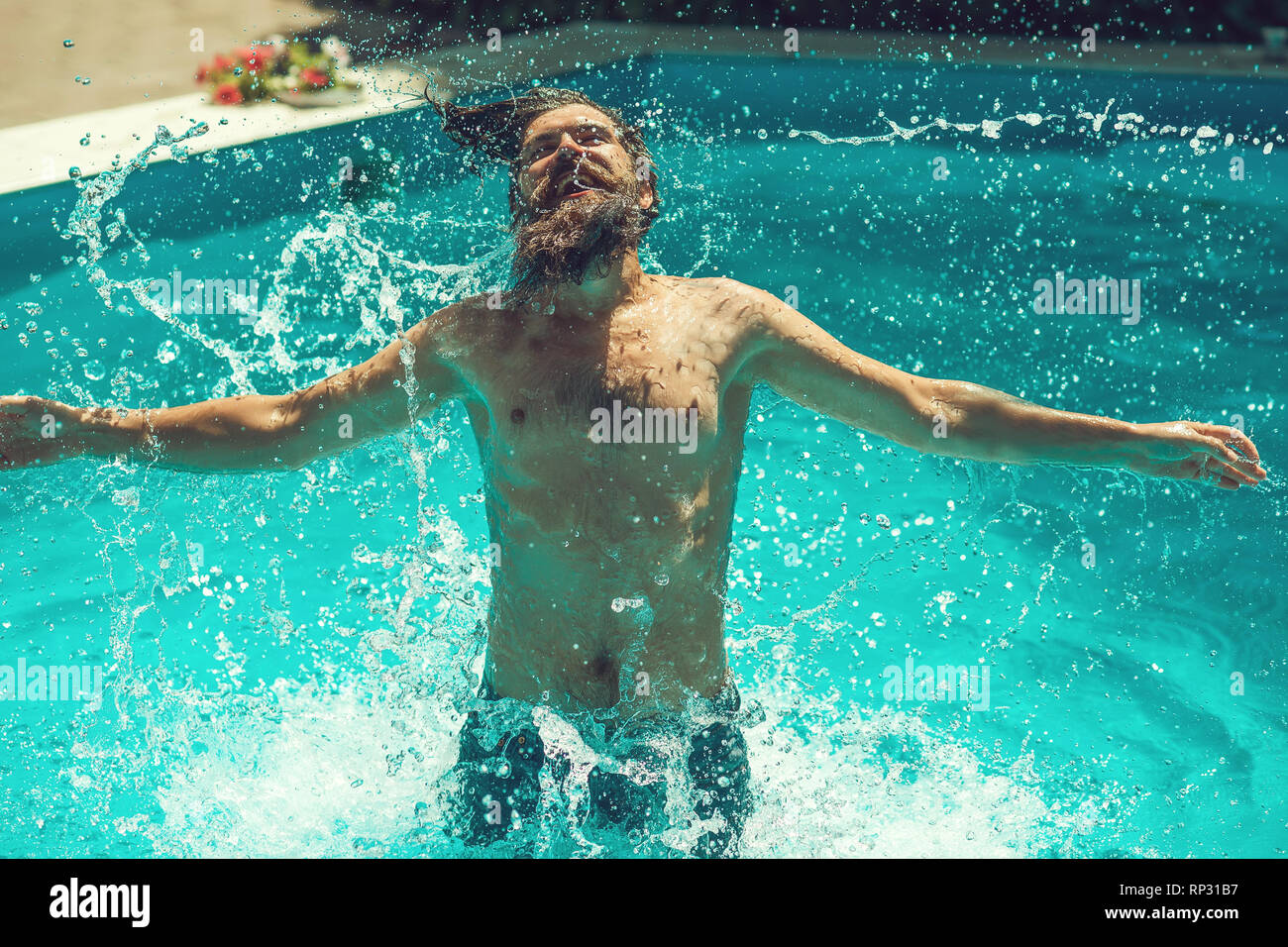 Young man splashing water Stock Photo - Alamy